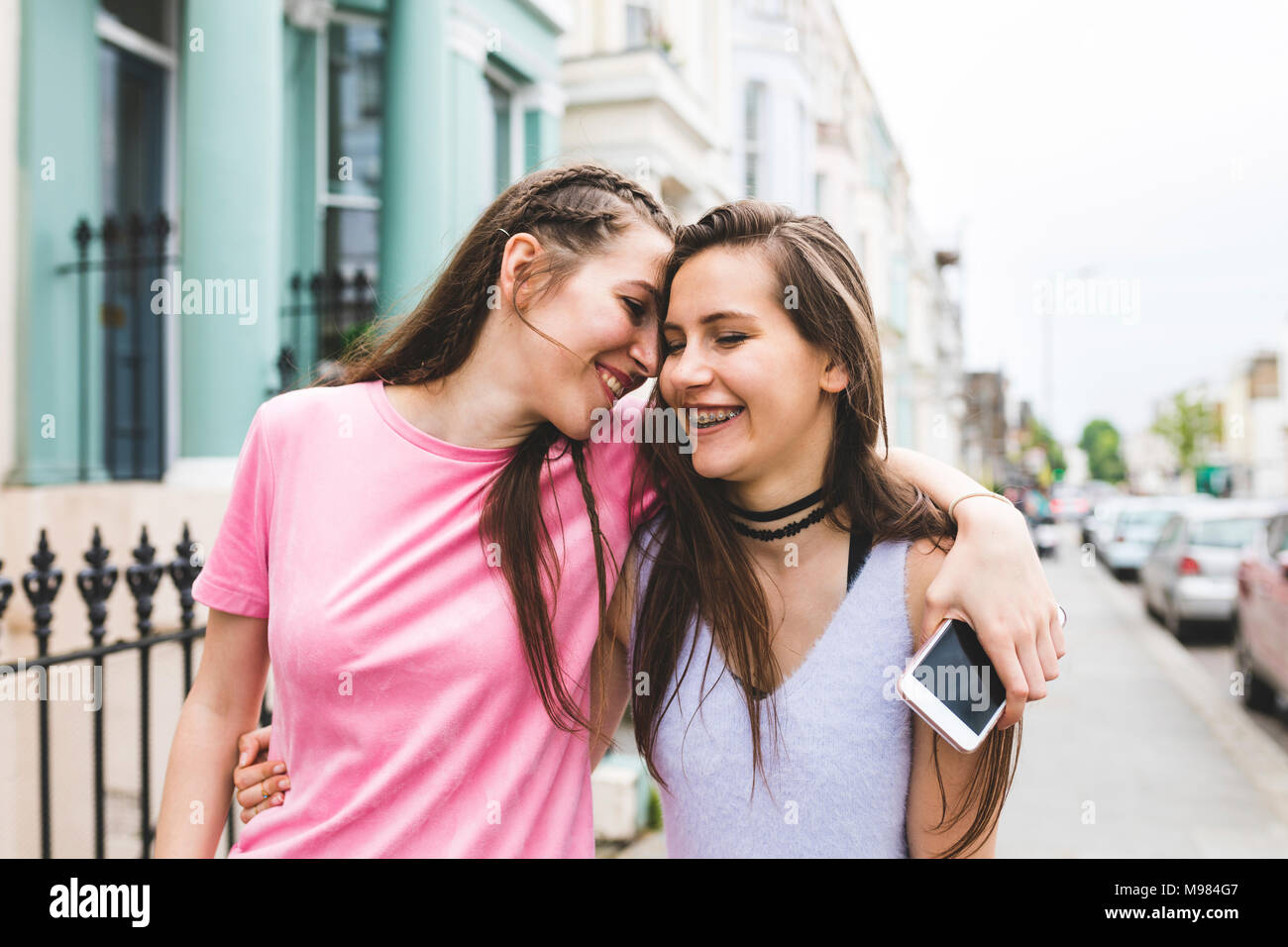 Zwei glückliche Mädchen im Teenageralter unterwegs in der Stadt Stockfotografie - Alamy