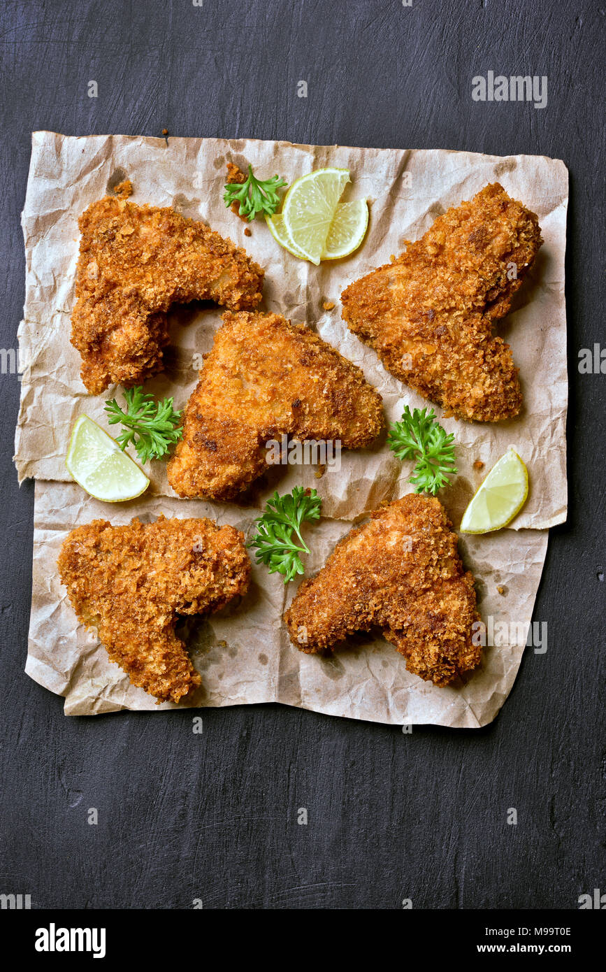 Spicy Fried Chicken Wings auf dem Papier über dunklen schwarzen ...