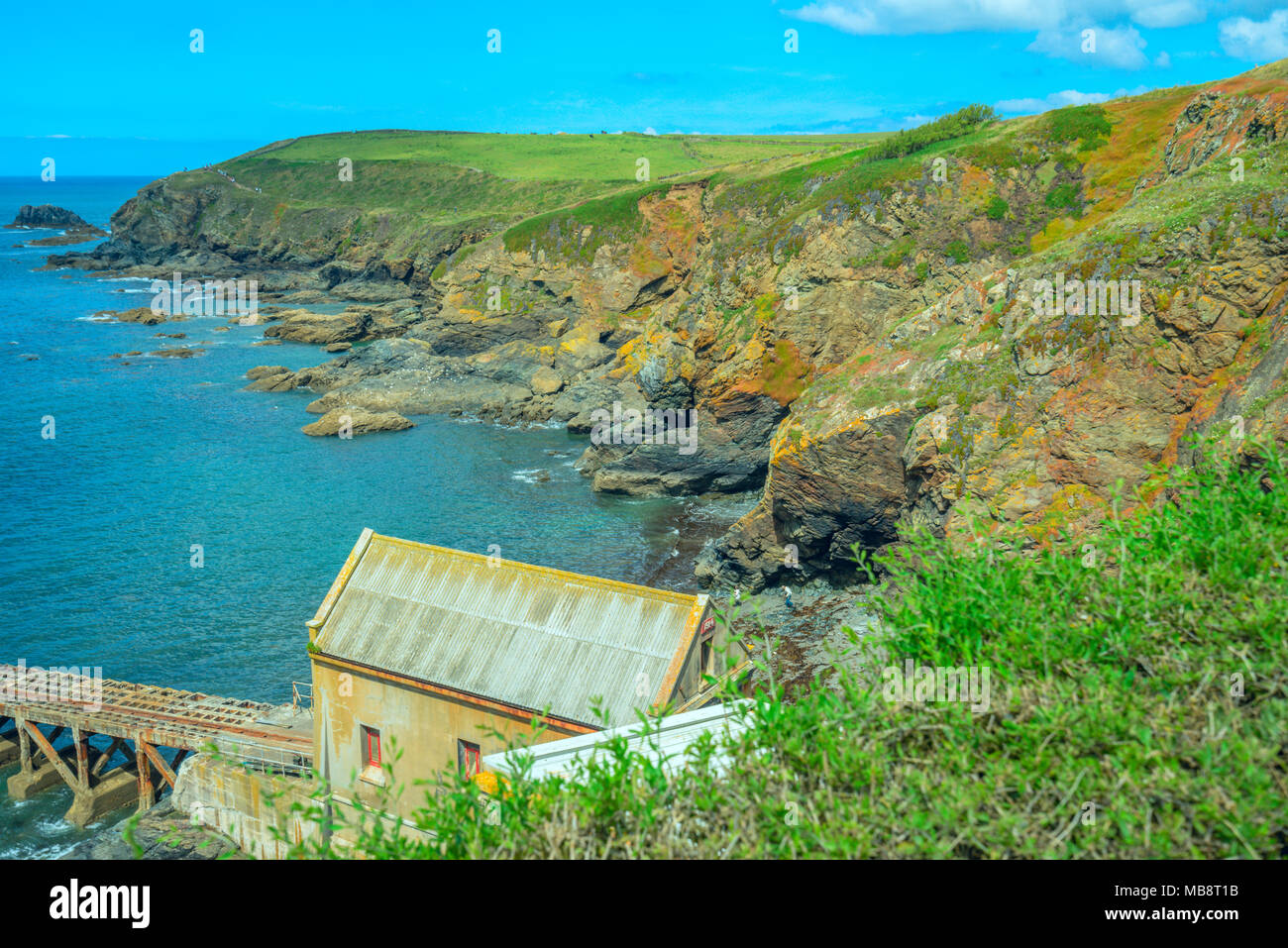 Ein bootshaus und Slipway am Lizard Point in Cornwall, mit Blick auf eine Bucht mit Felsen ...