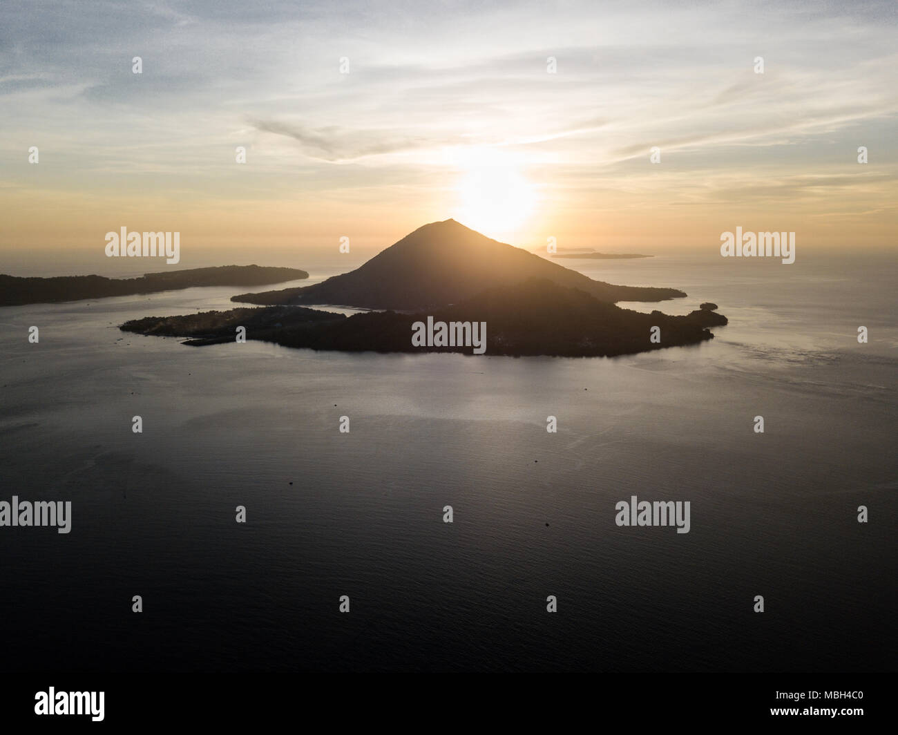 Die Sonne geht hinter Banda Neira, einem aktiven Vulkan in der Banda ...