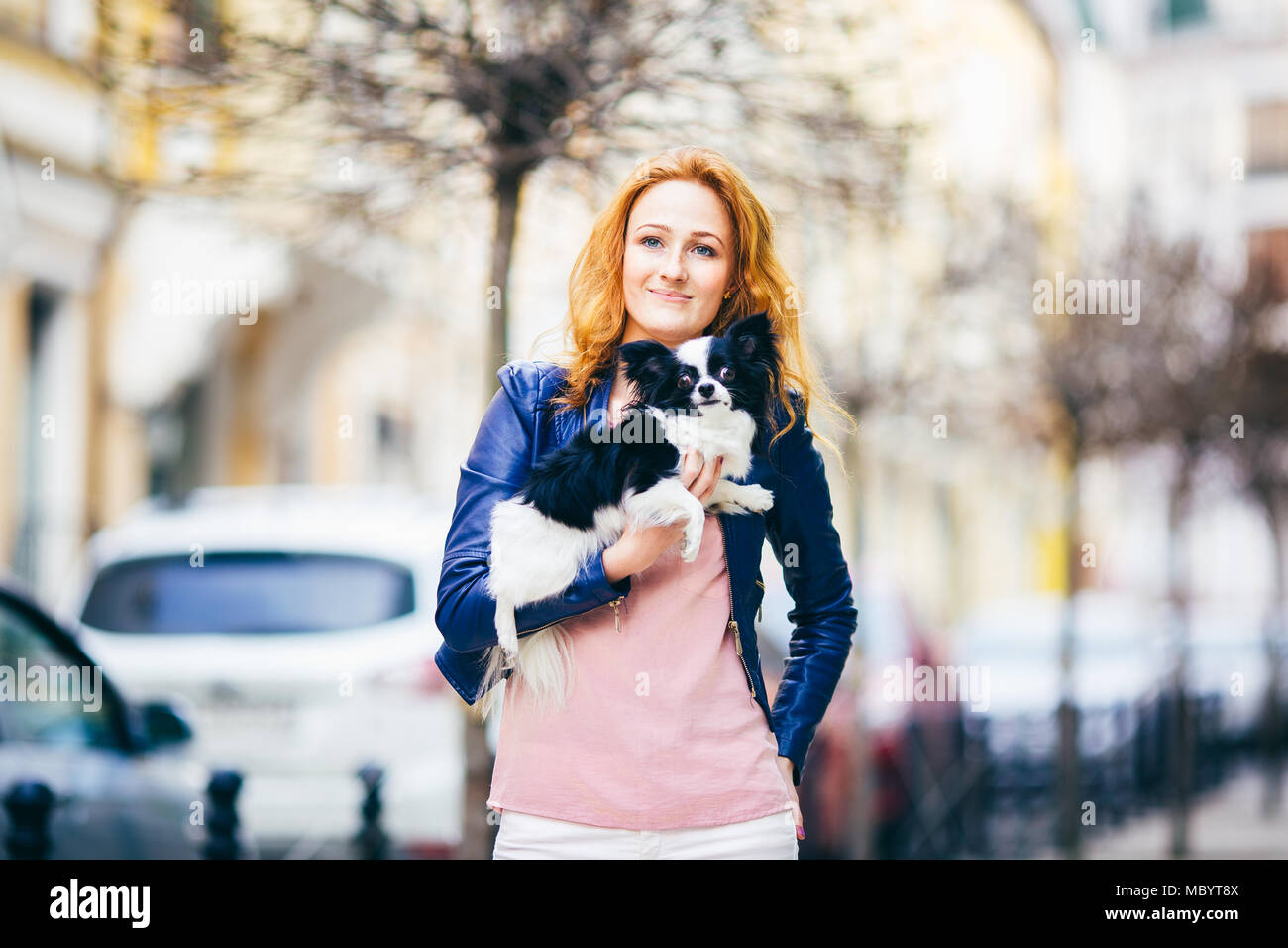 Thema Mensch und Hund. Eine junge Rothaarige kaukasische Frau mit ...