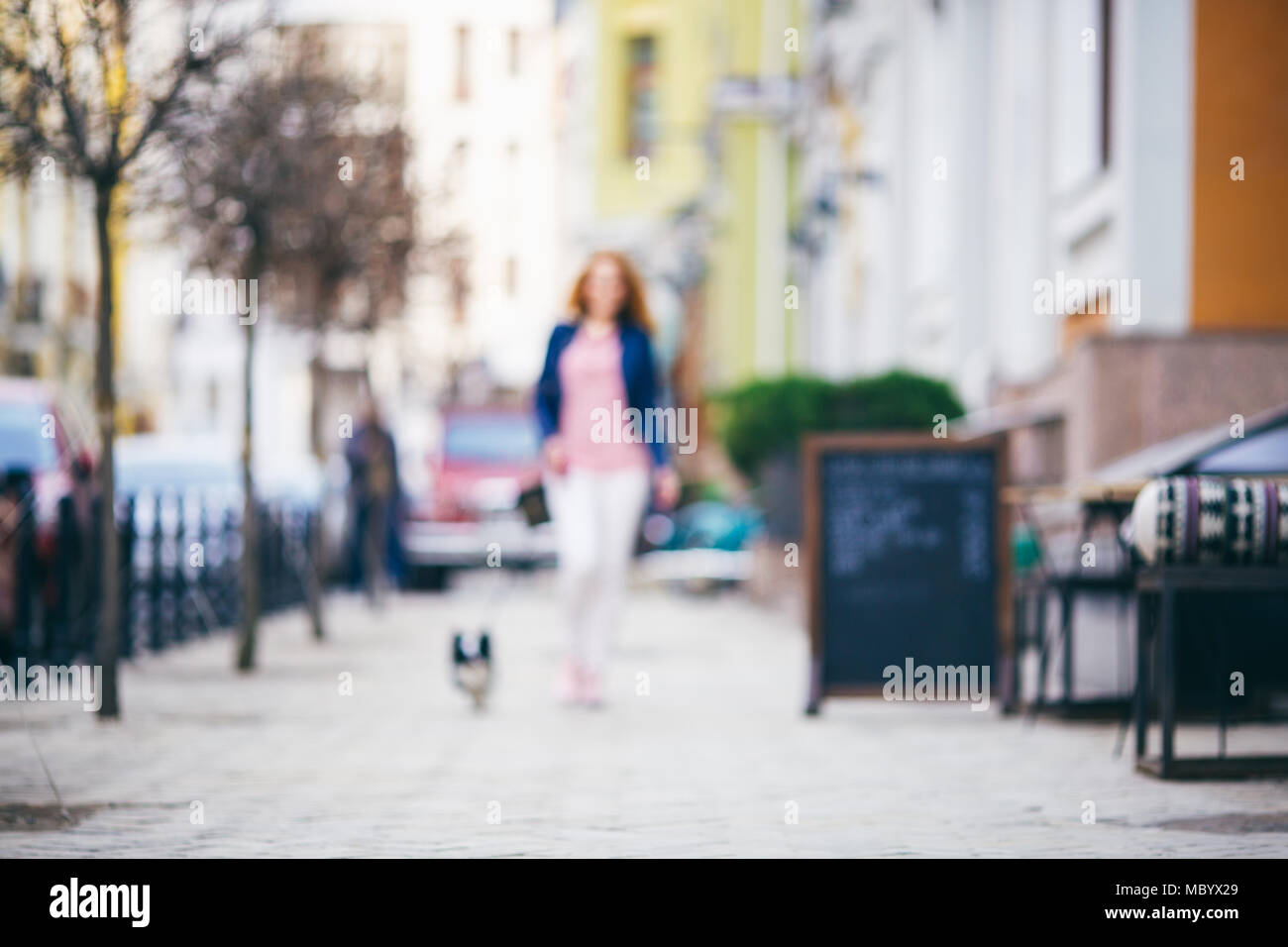 Unscharfer Hintergrund eine junge Rothaarige kaukasische Frau entlang ...