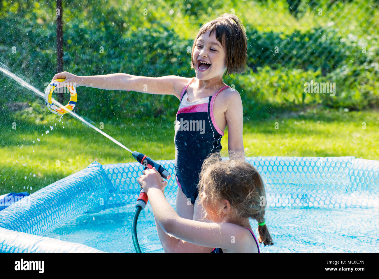 Zwei Mädchen Spaß Im Pool Im Freien Spiel Mit Dem Wasserschlauch