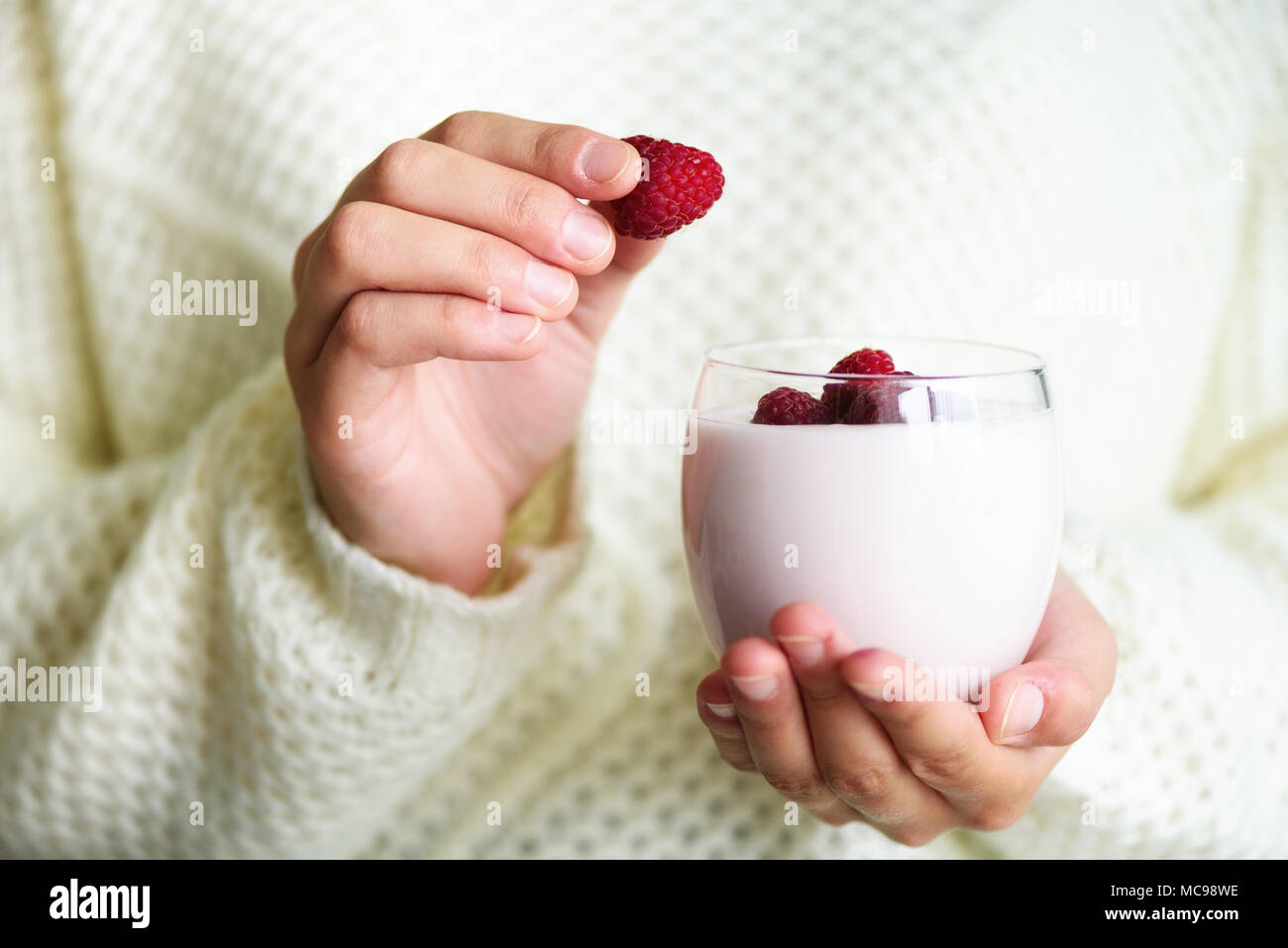 Mädchen hält Glas Milch oder Joghurt, Kefir mit Himbeeren. Gesund und ...