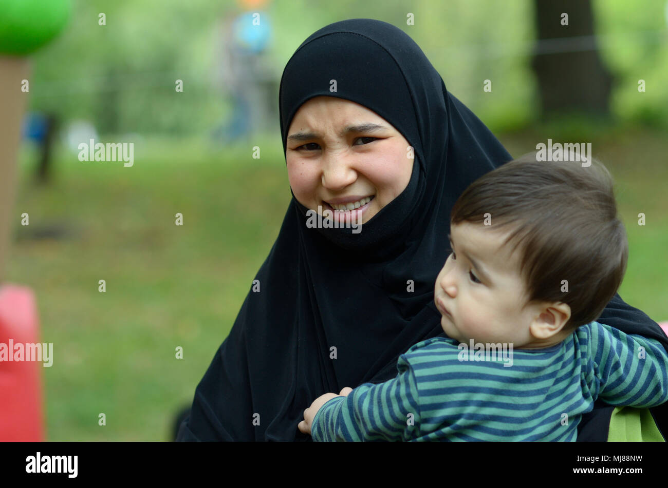 Muslimische Frau in hijabs Baby auf dem Arm. Feier der Hidirellez ...