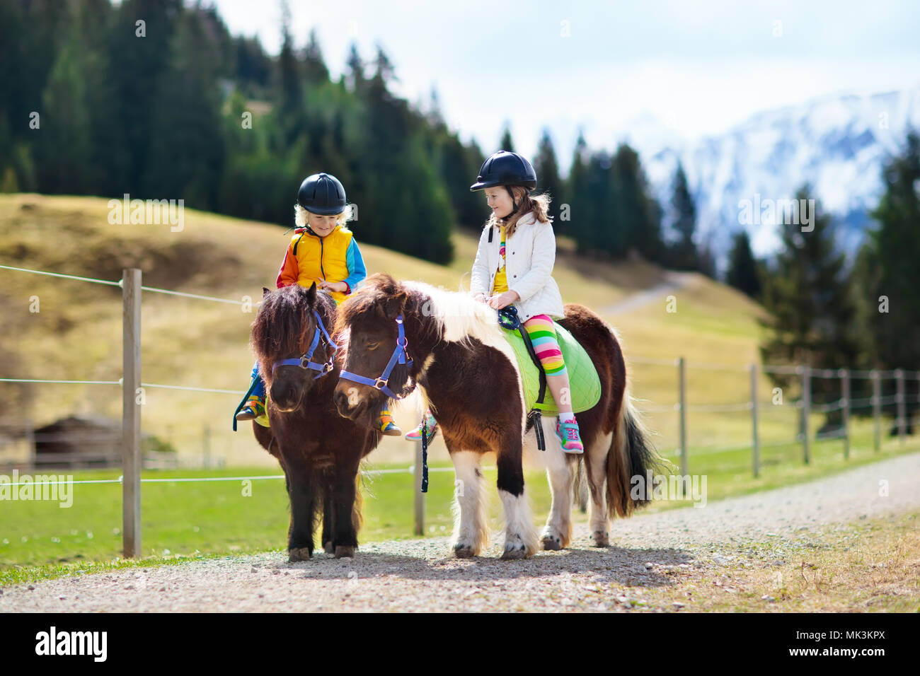 Kinder reiten Pony in den Alpen. Familie Frühling Ferien auf Horse ...