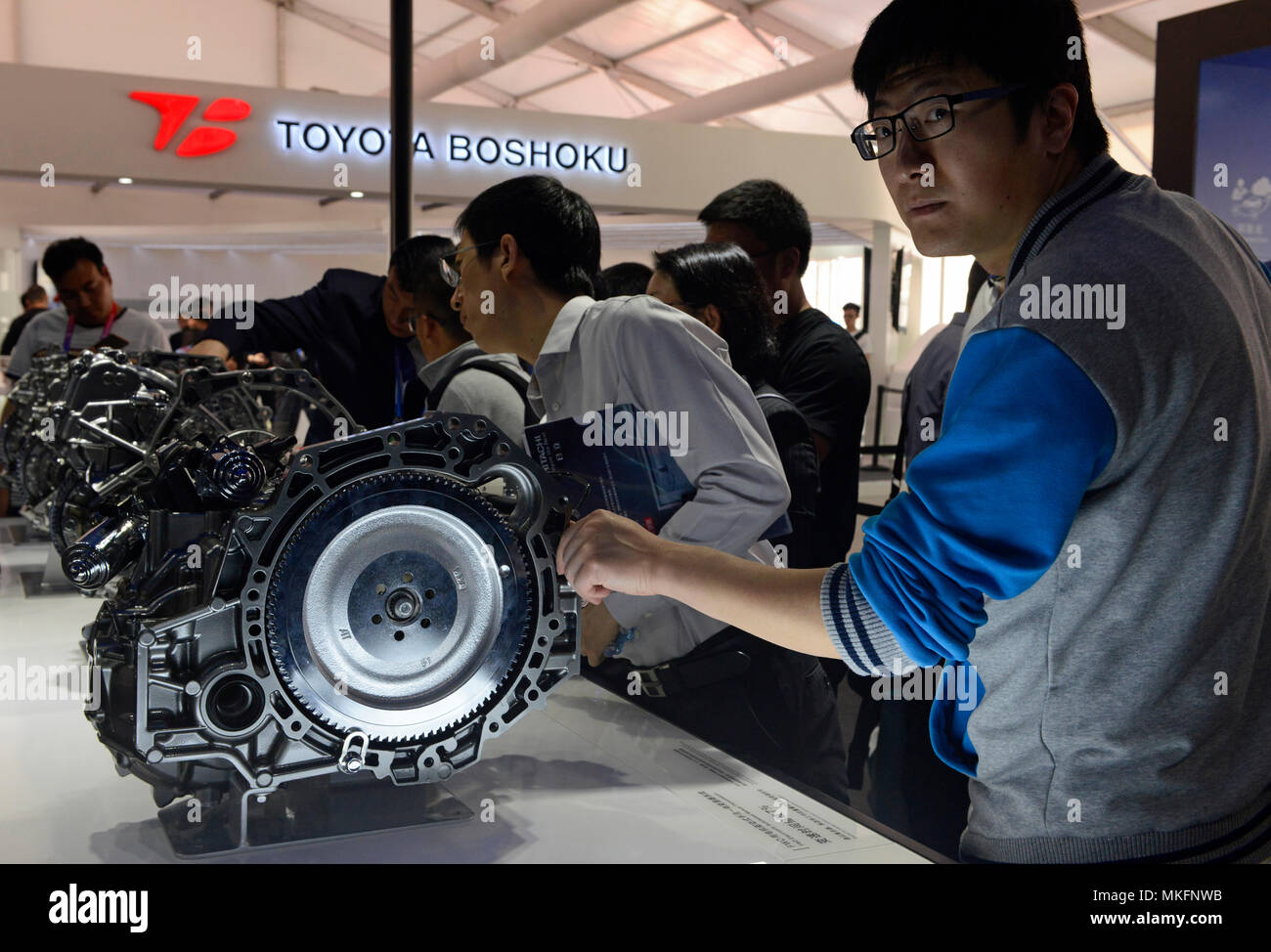 Ein Besucher untersucht ein Automatikgetriebe AISIN auf der Messestand ...