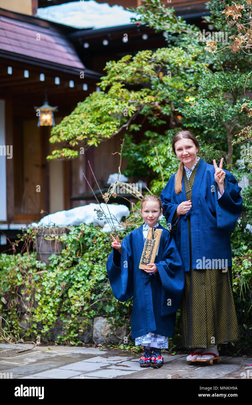 Familie von Mutter und Tochter tragen traditionelle japanische Kimono yukata an der Straße von ...