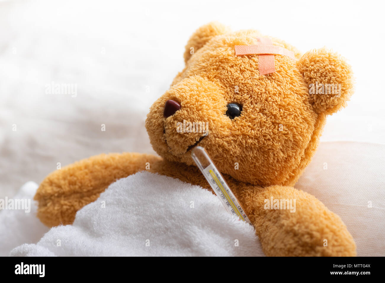 Teddy Bär krank im Krankenhaus Bett mit mit Thermometer und Gips ...