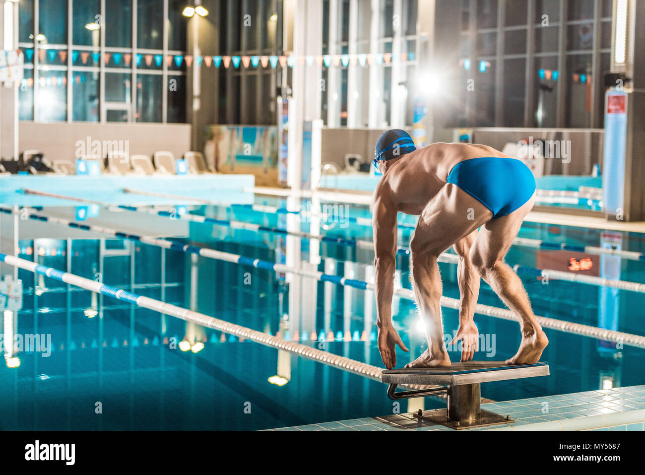 Schwimmer stehen auf Sprungbrett in den Wettbewerb Pool zu springen ...