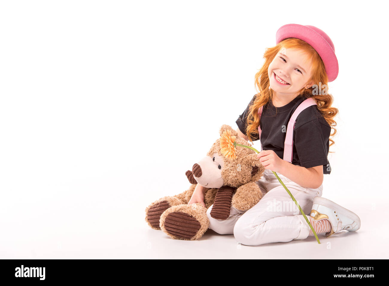 Lächelnd rote Haare Kind sitzend mit Teddybär und Blüten auf Weiß ...