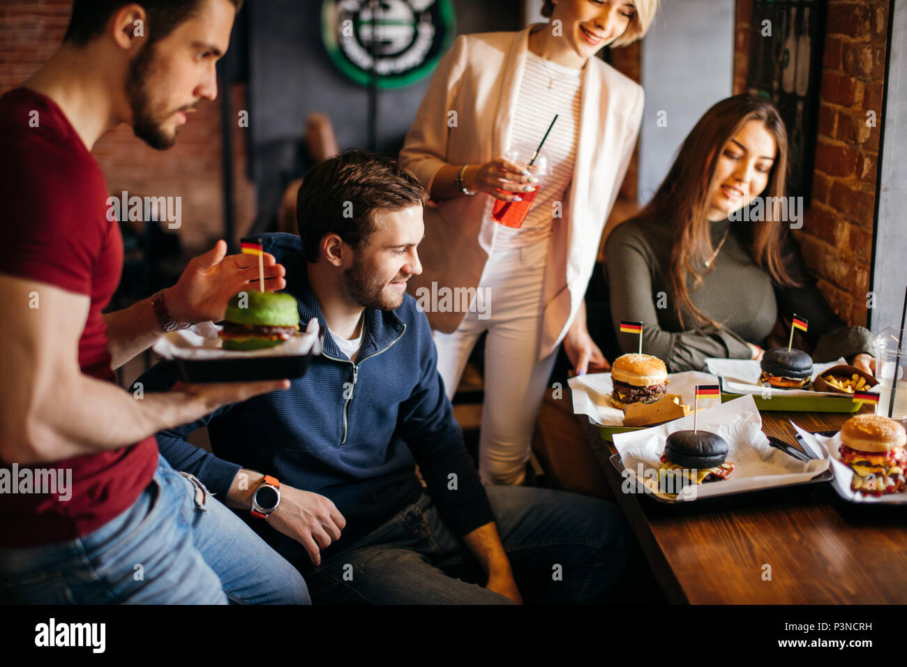 Höfliche junge Kellner bringen bestellt Burger zu Gast im Restaurant ...