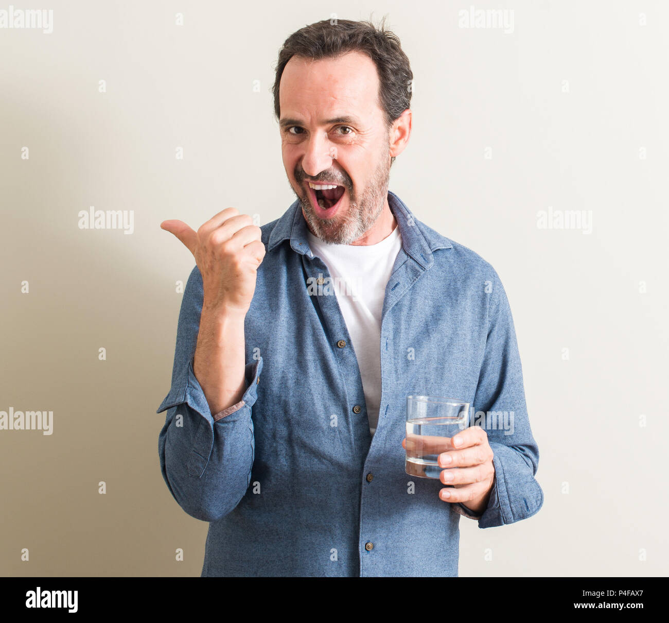 Ältere Menschen trinken Wasser im Glas zeigt mit Finger- und oben mit ...