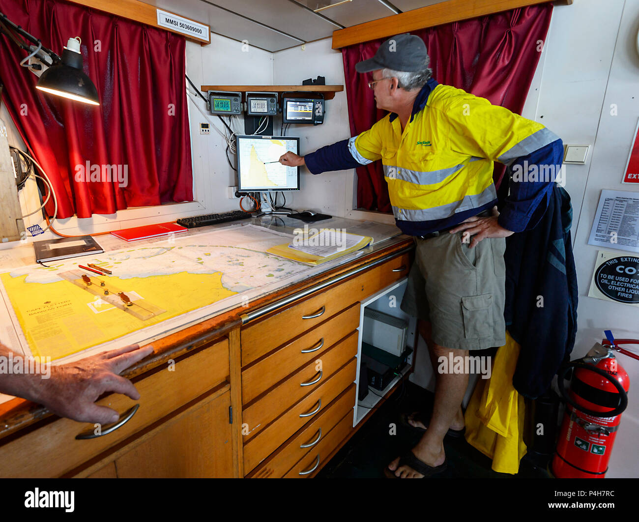 Kapitän, der auf eine Karte mit Route des Schiffes auf der Brücke von M ...