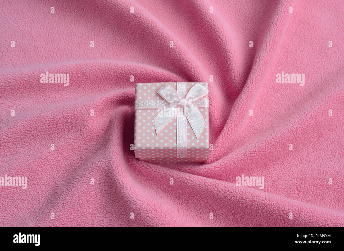 Ein kleines Geschenk Box in Rosa mit einer kleinen Verbeugung liegt auf ...