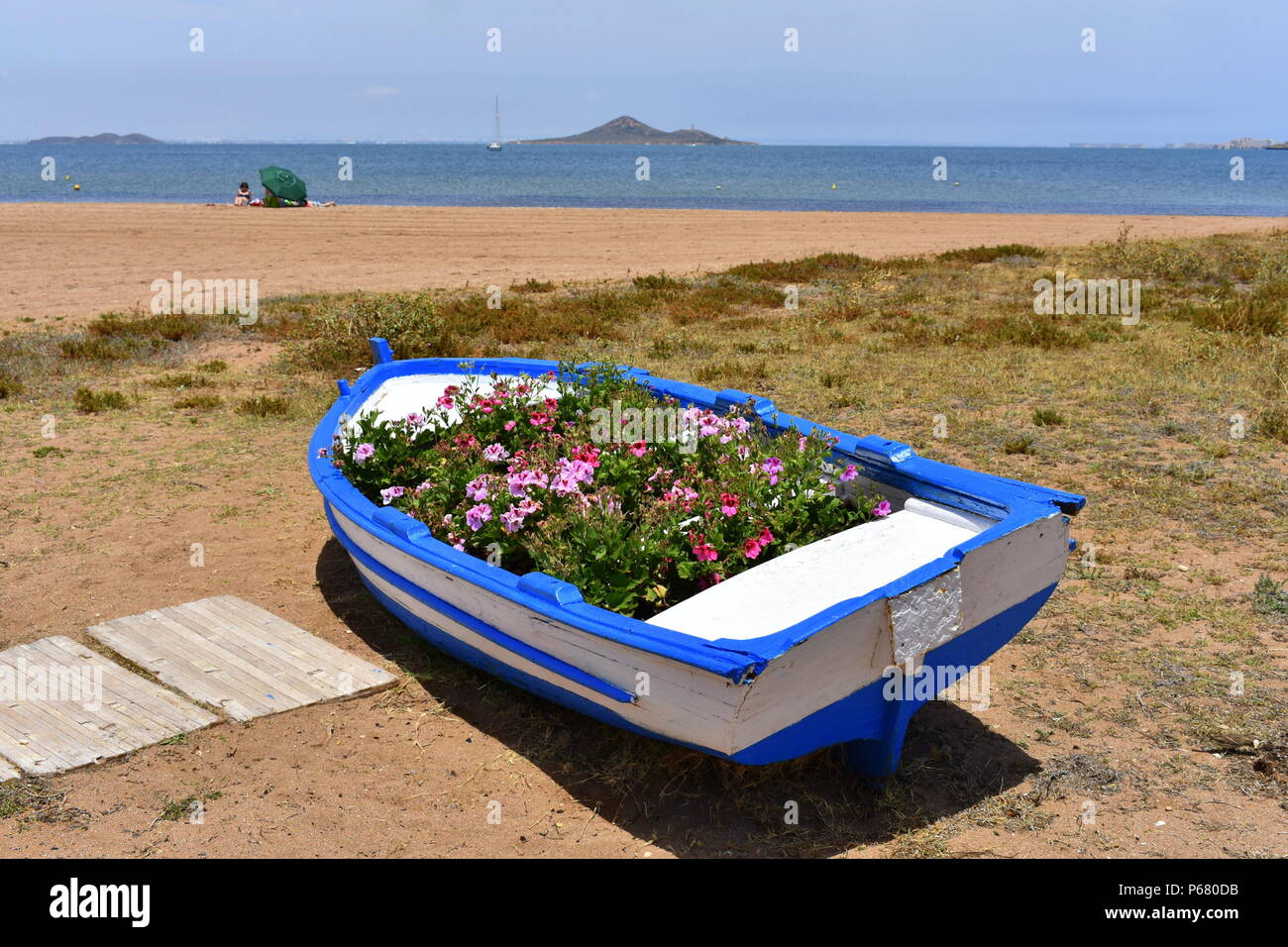 Blaue und weiße Boot voller Blumen am Strand von Mar de Cristal, Mar ...