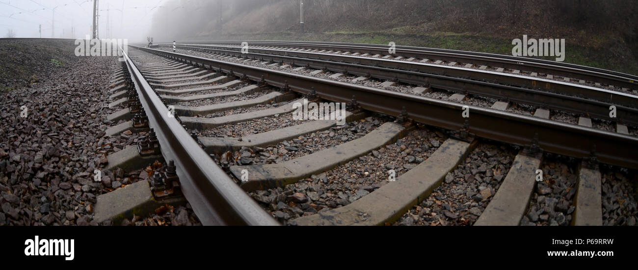 Die Eisenbahnstrecke in einem nebligen Morgen. Eine Menge Schienen und ...