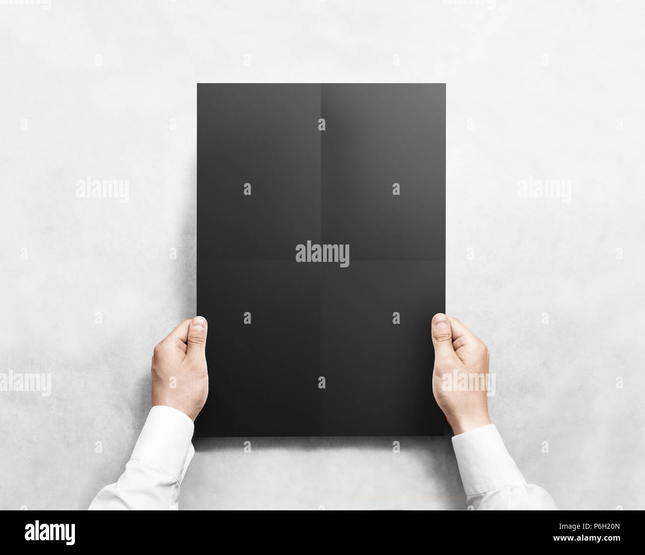 Hand, schwarz gefaltete Leere poster Mockup, isoliert. Arm shirt Halten ...