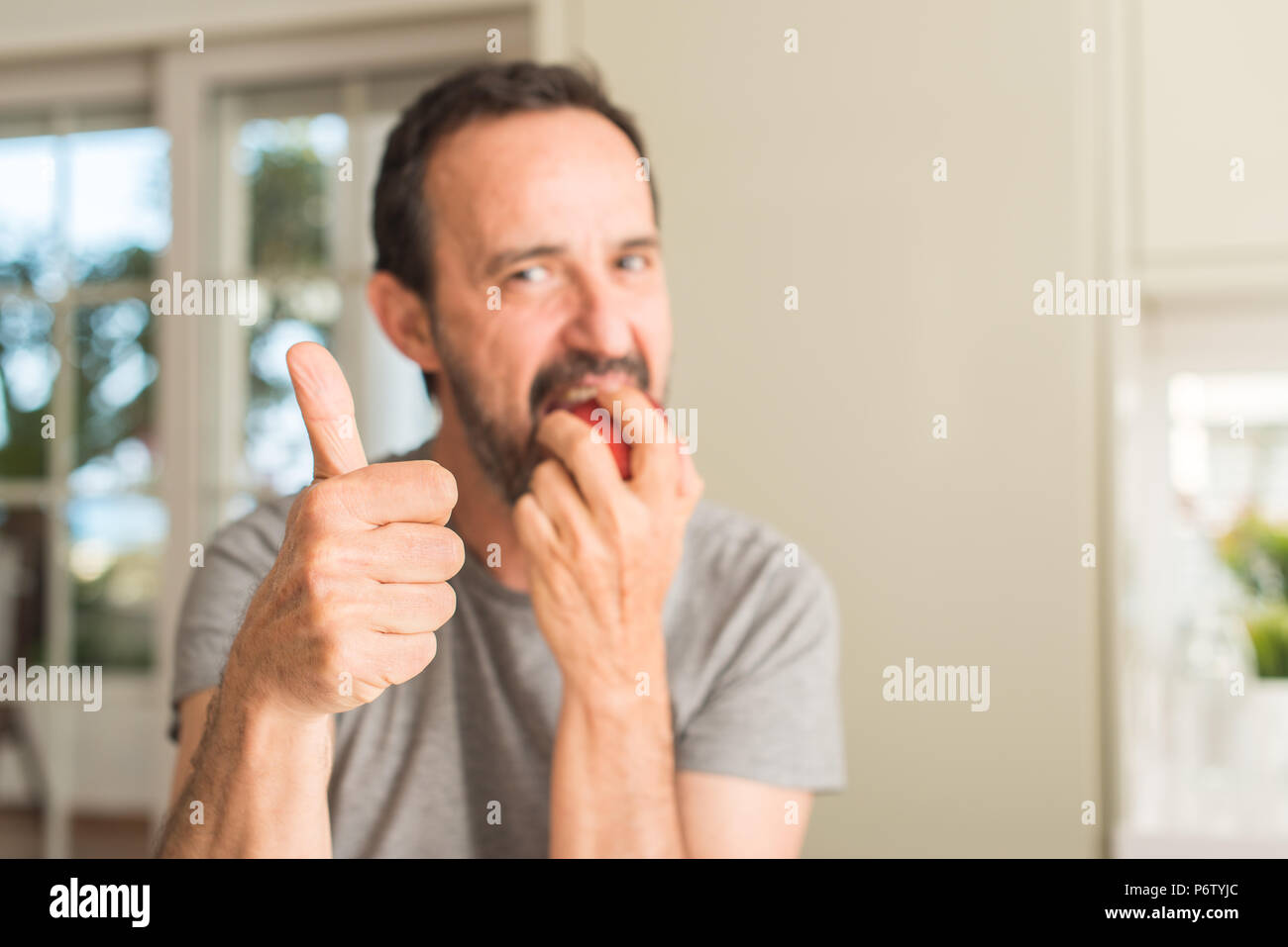 Mittleres Alter Mann gesund essen red apple zufrieden mit Lächeln tun ...