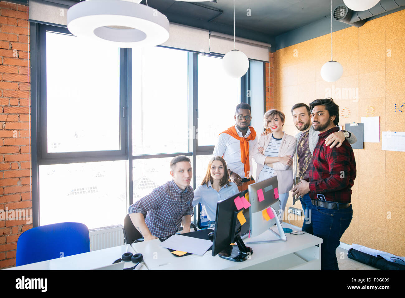 Foto von wunderschöne junge startup Team auf die Kamera in der Loft ...
