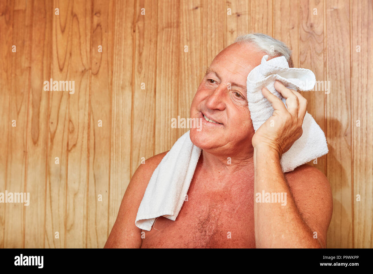 Alter Mann wischt sich den Schweiß von seiner Stirn in der Sauna des ...