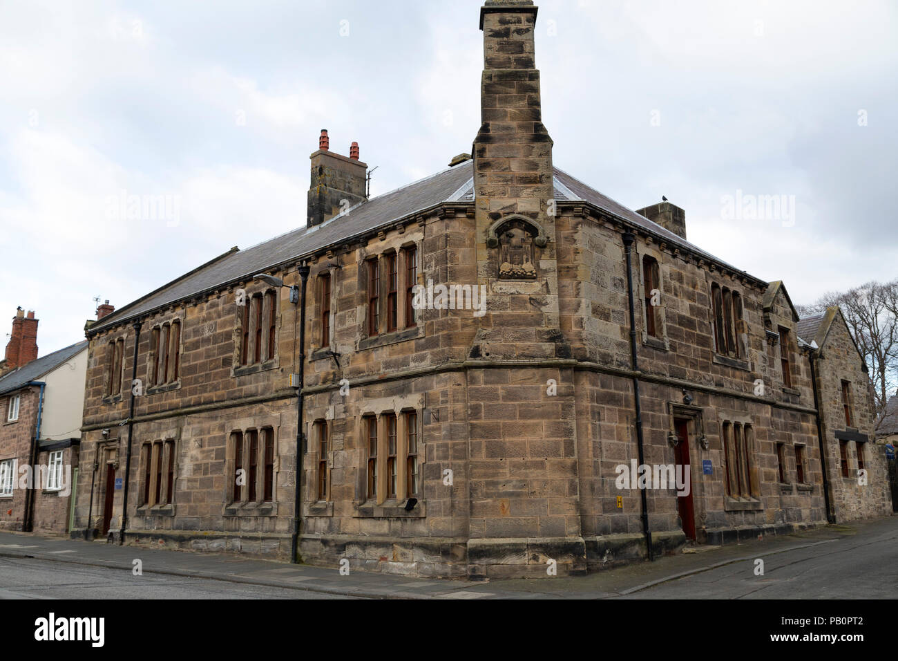 Gebäude aus Stein mit Maßwerk in Northumberland, England. Schornsteine ...