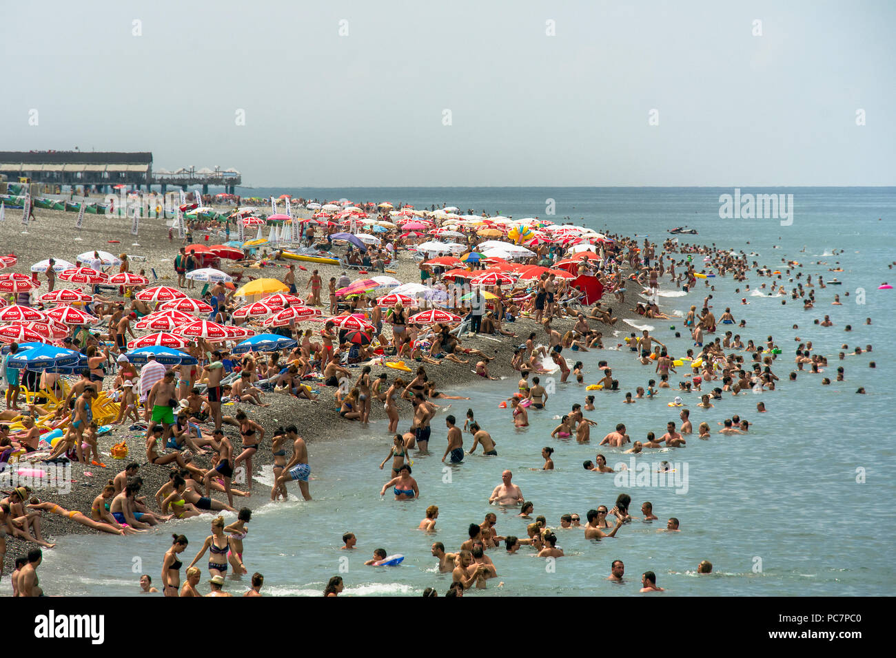 Horden von Sonnenanbetern und Strandurlauber Masse der Kies und ...