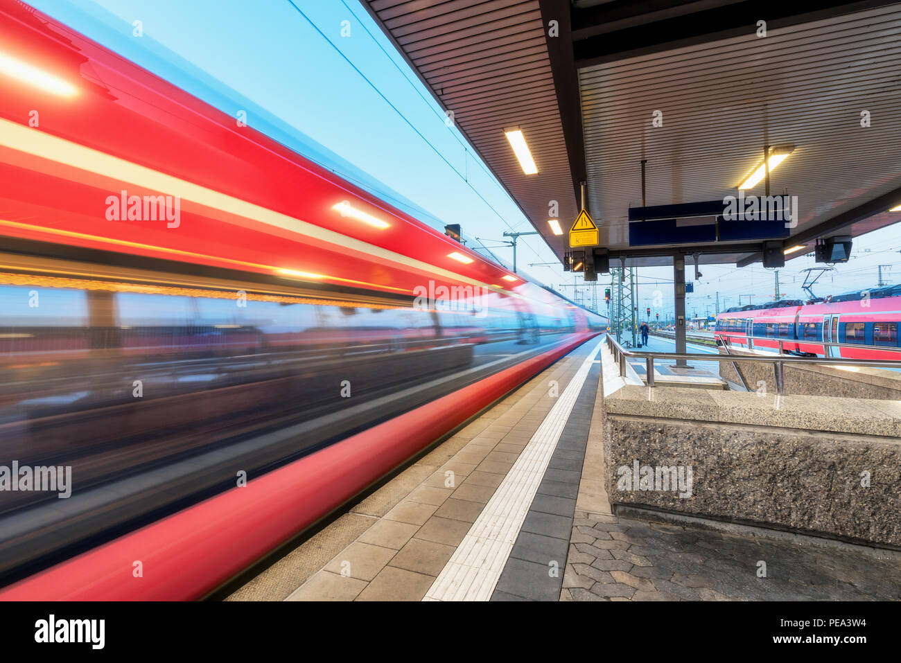 High speed Zug in Bewegung auf dem Bahnhof bei Sonnenuntergang. Bewegen ...