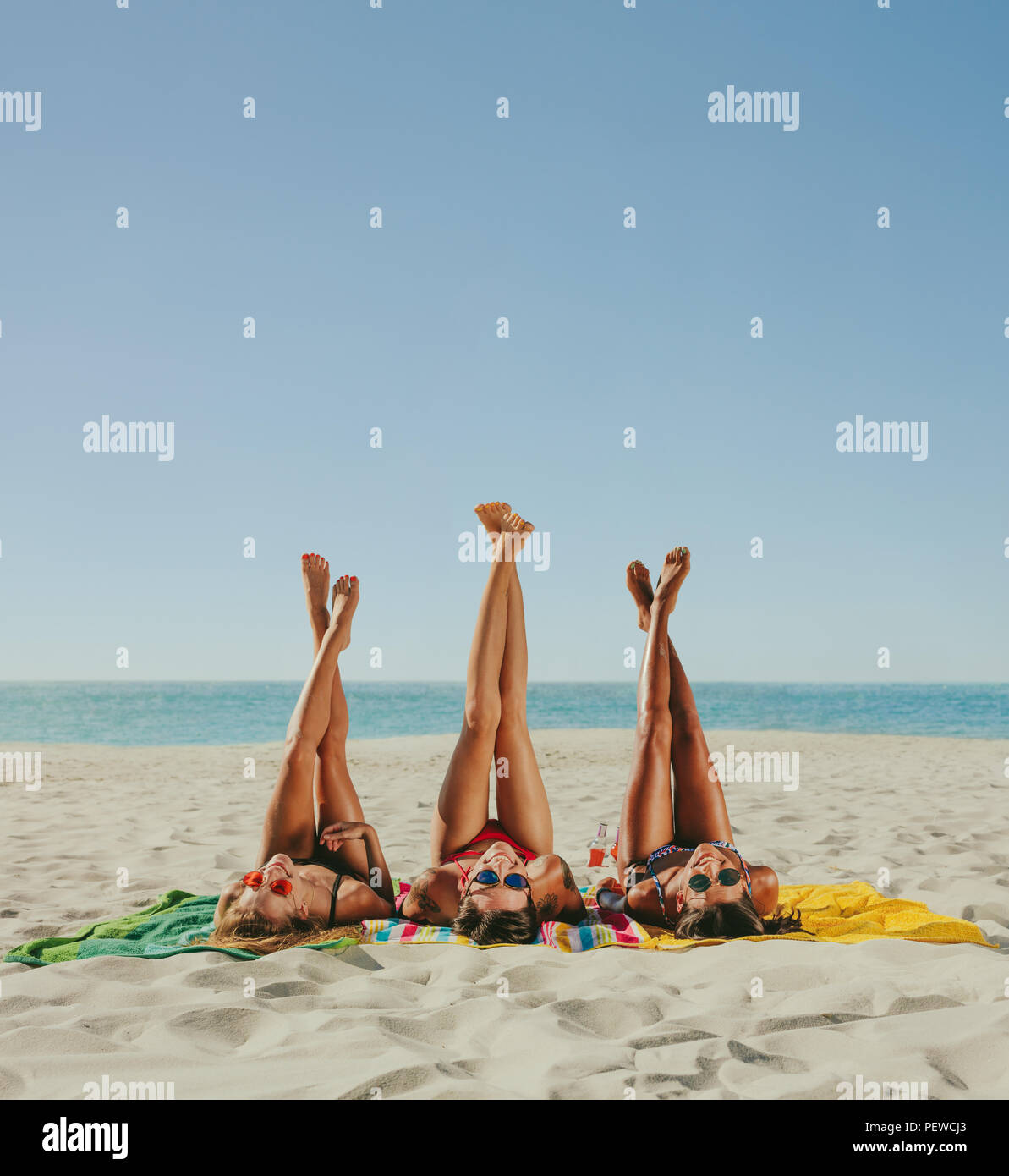 Drei Freundinnen Liegen Am Strand Im Bikini Sonnen Posieren Für Fotos Mit Gekreuzten Beinen Und