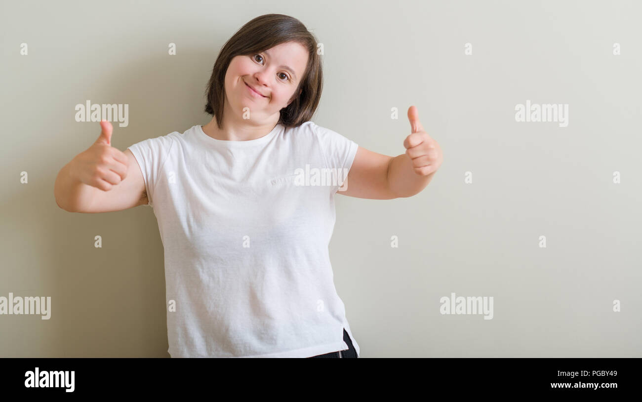 Down Syndrom Frau stehend über Wand erfolg Zeichen tun positive Geste ...