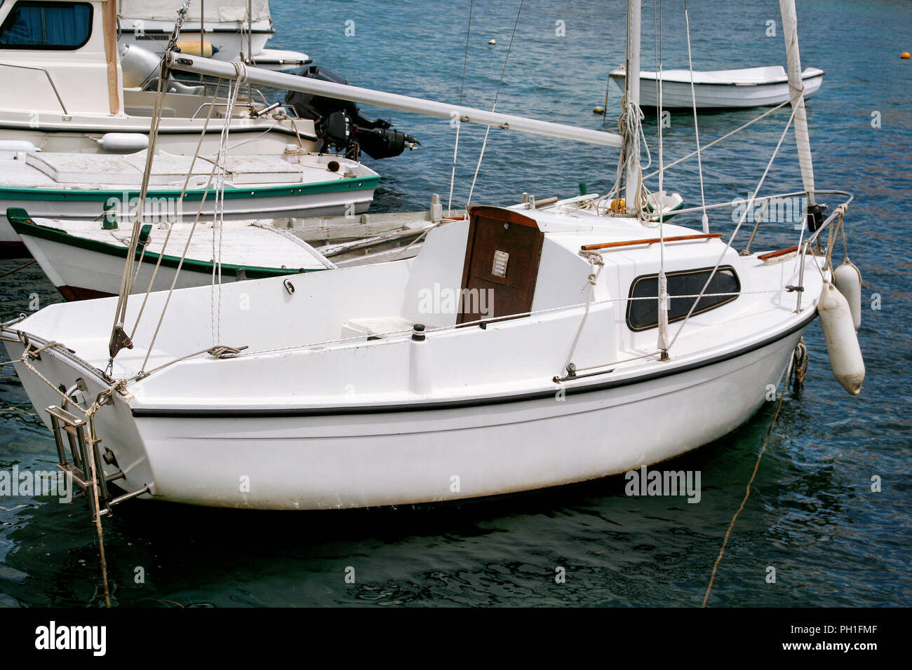 Kleine weiße Segelboot im Hafen. Motorboot im Hafen mit Holztür ...