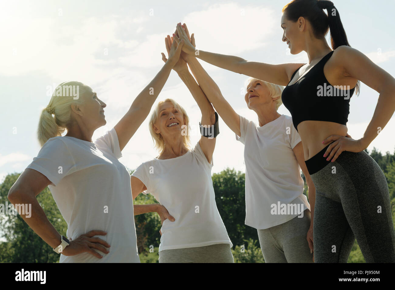 Ältere Damen und ihre Trainer hohe FIVING nach dem Workout ...