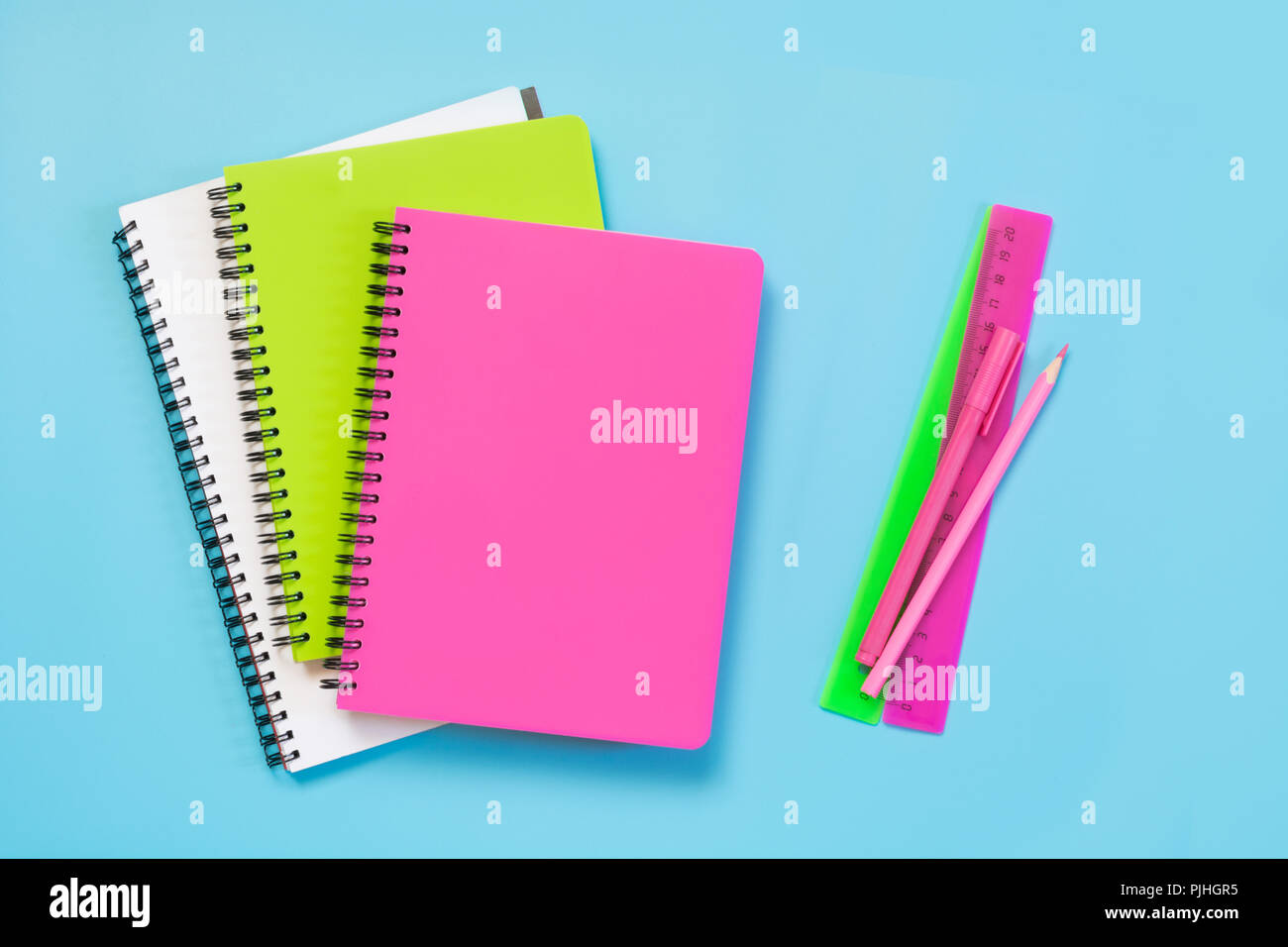 Bunte mädchenhafte Schulmaterial, Hefte und Stifte auf druckvolle Blau ...