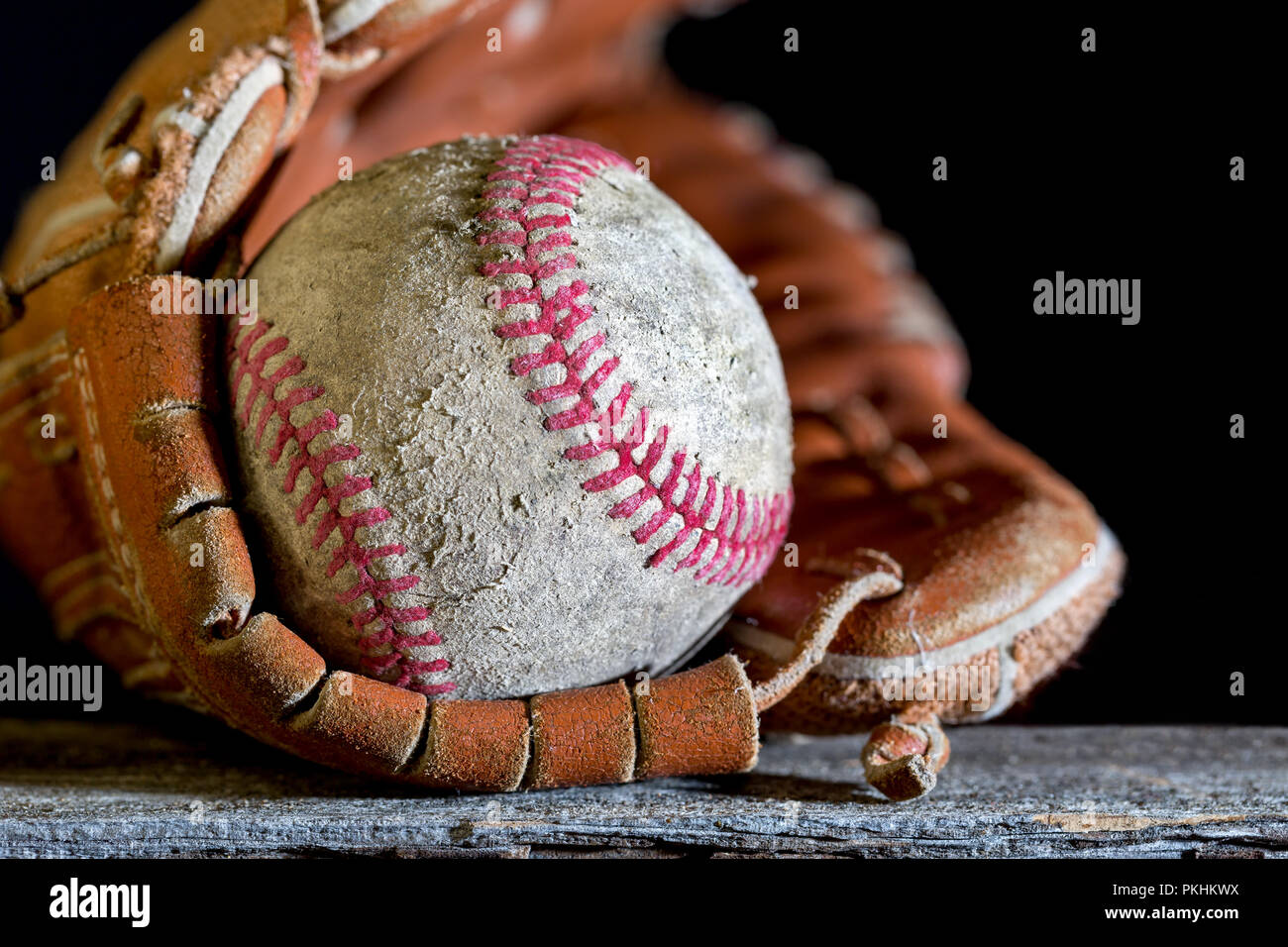 Baseball Handschuh und Ball auf verwittertes Holz Bank. Nahaufnahme mit ...