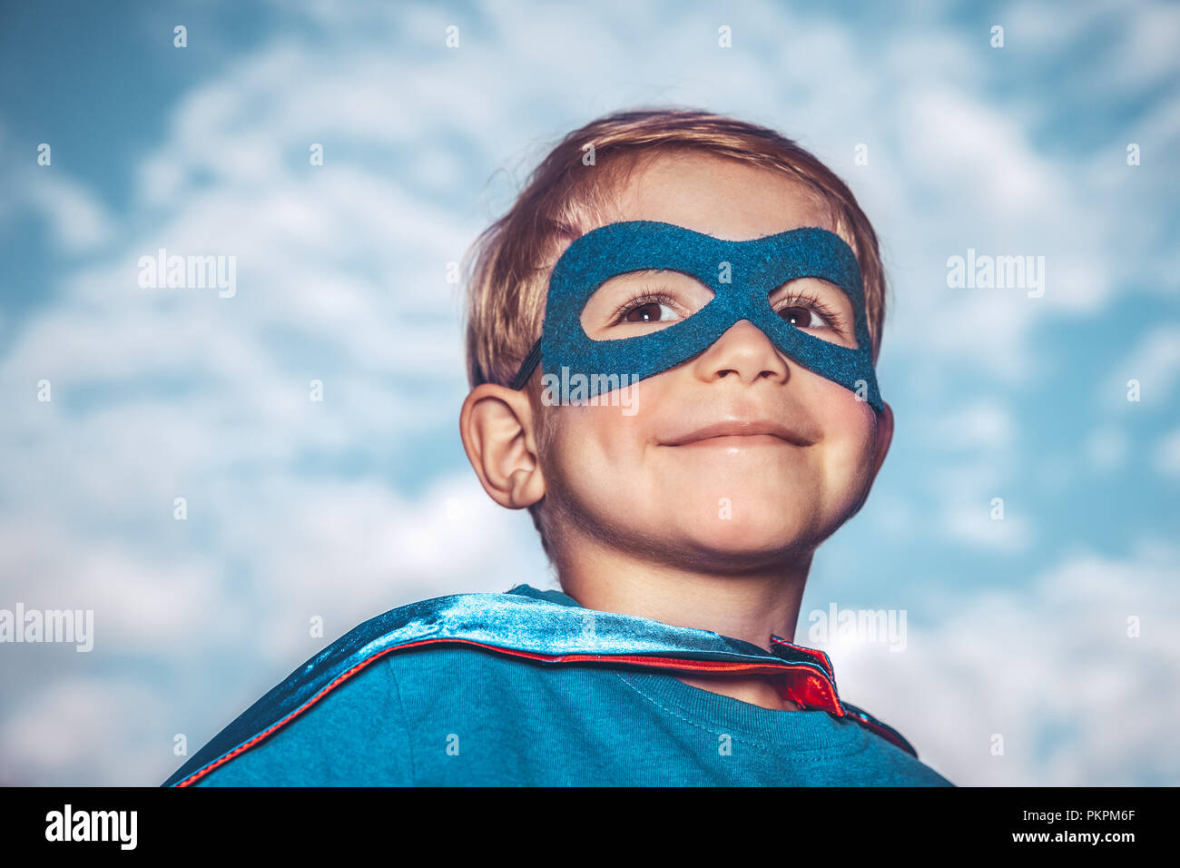 Closeup Portrait von einer netten kleinen Superhelden über blauer ...