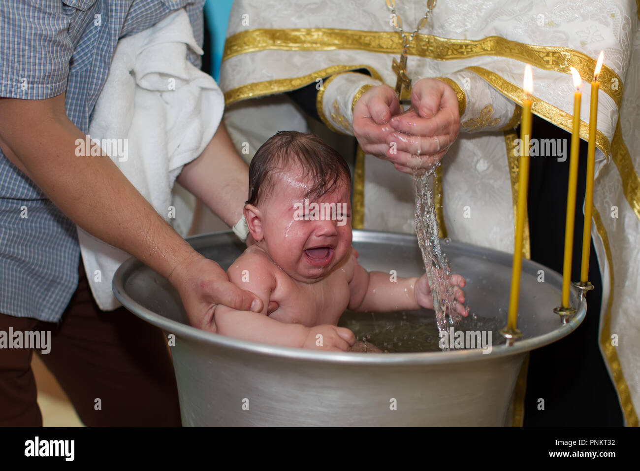 Die Taufe eines Kindes. Waschung im heiligen Wasser. Annahme glauben ...