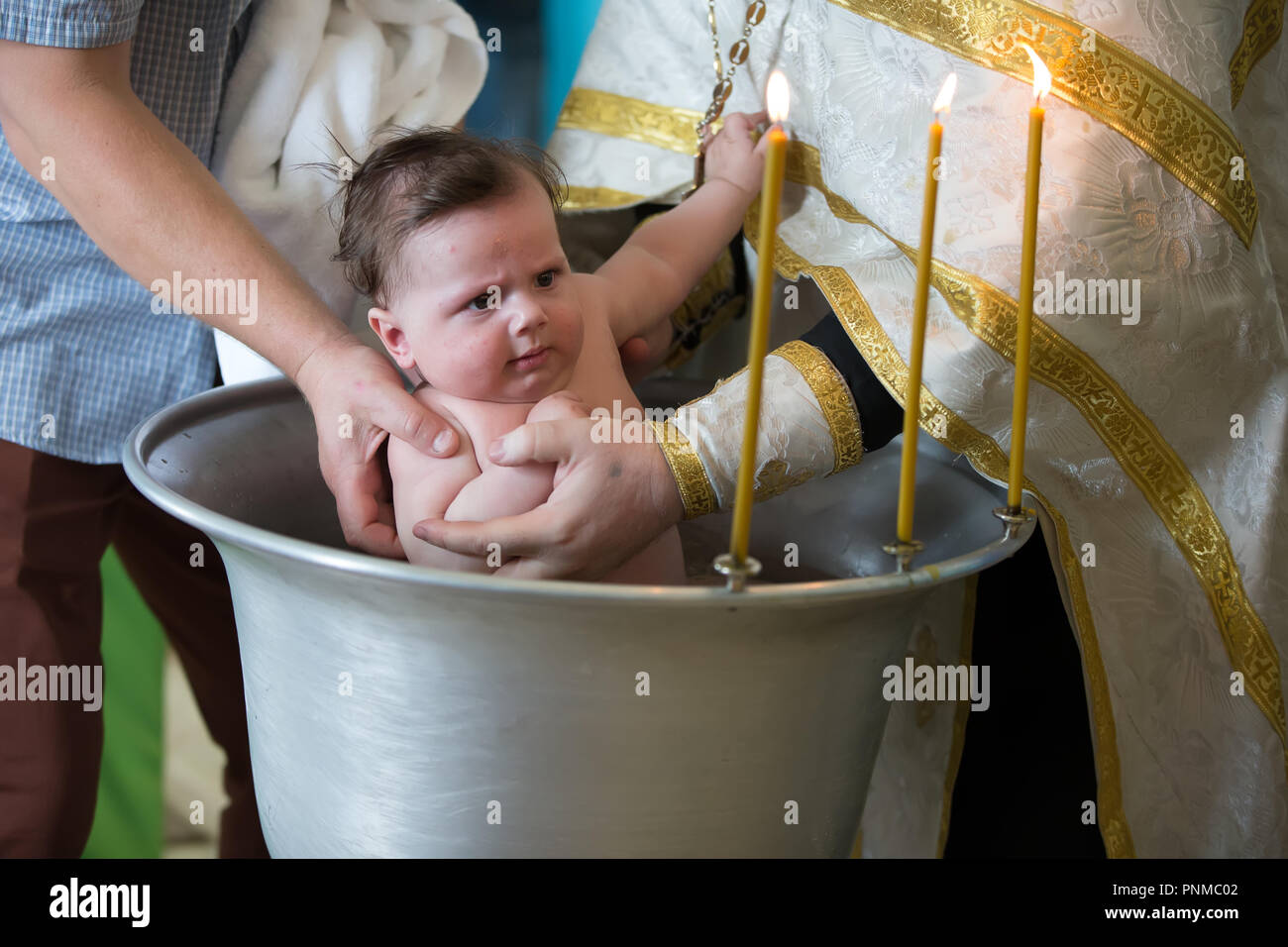 Die Taufe eines Kindes. Waschung im heiligen Wasser. Annahme glauben ...