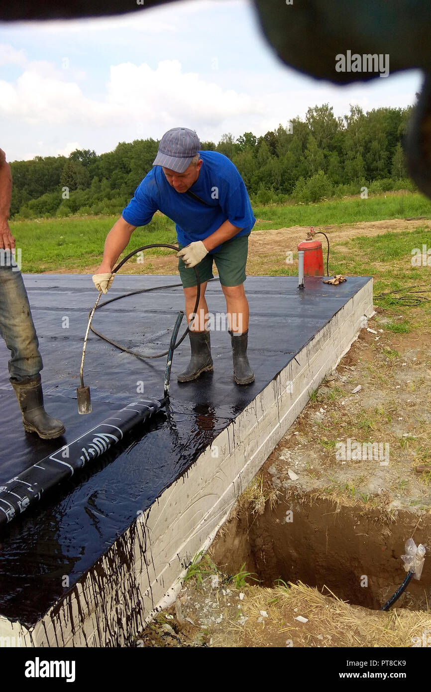 Professionelle Installation der Abdichtung auf dem Betonfundament zwei ...