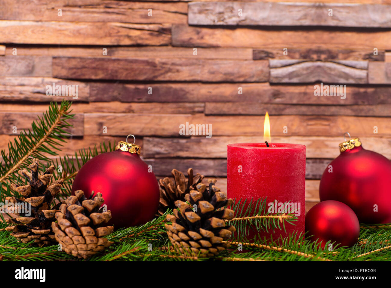 Weihnachtsdekoration mit Kerze, Christbaum Kugeln, Tannenzweigen und ...