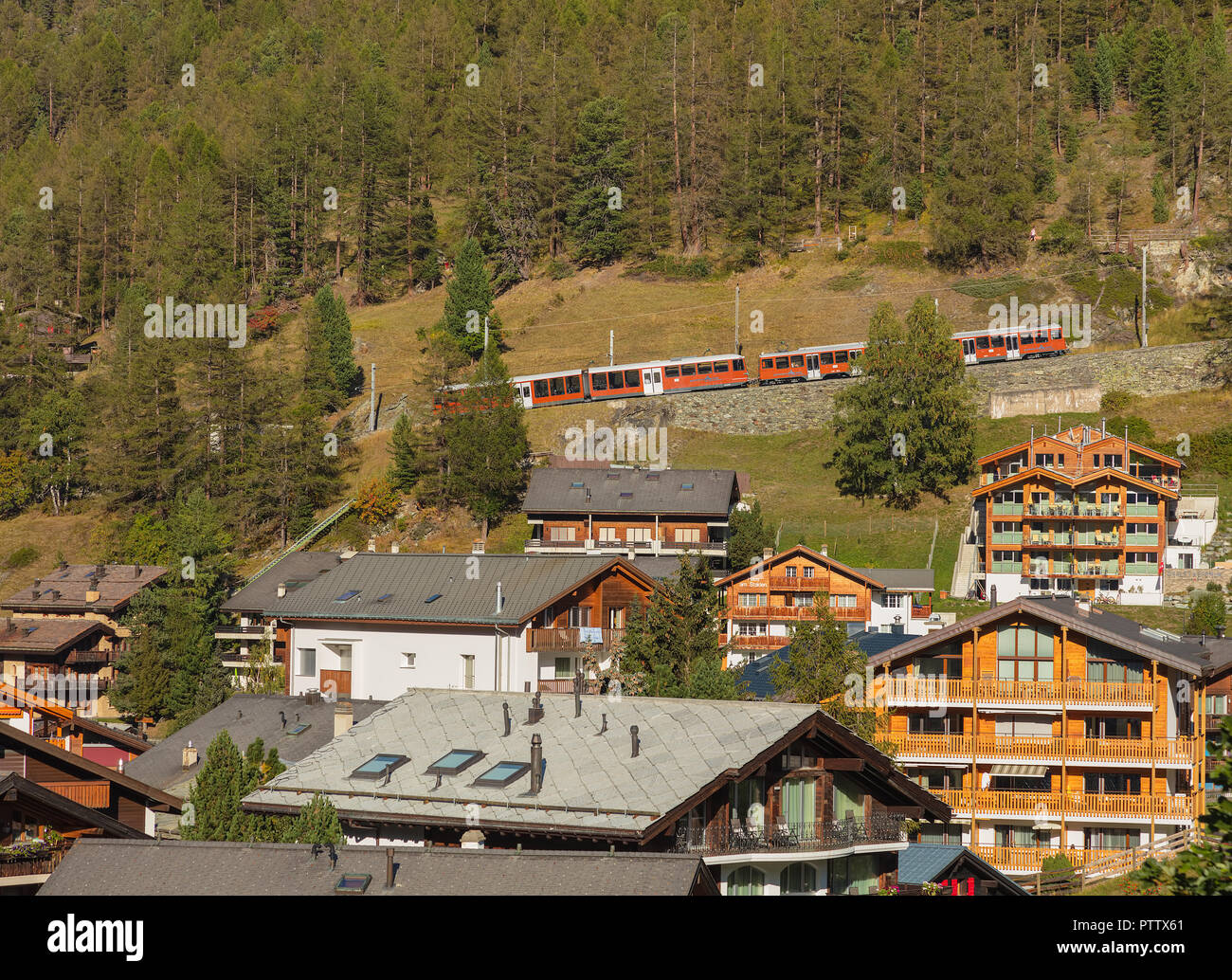 Gebäude der Stadt von Zermatt, Gornergrat Bahn Zug passiert im ...