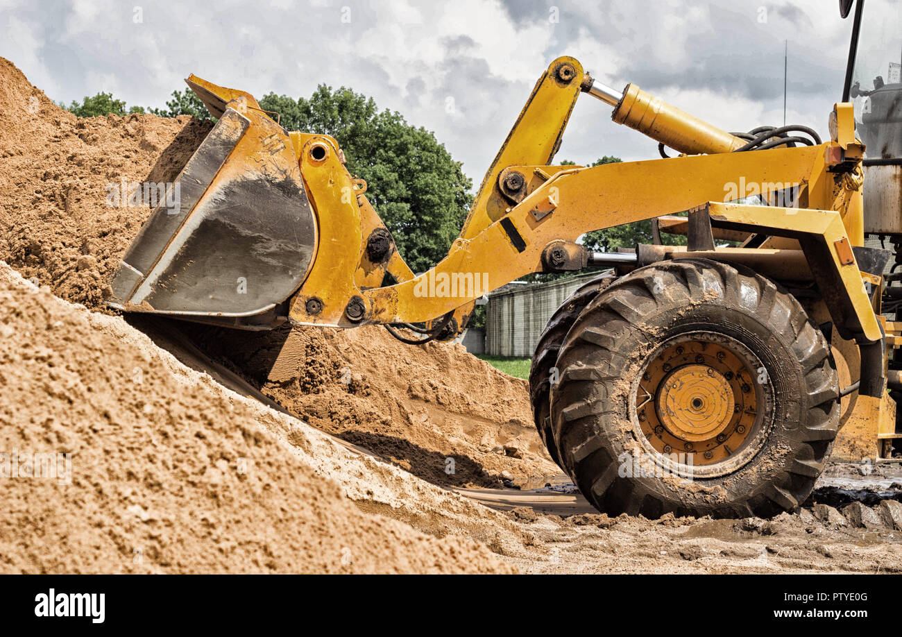 Gelbe Traktor Lader nimmt einen Eimer mit Erde, mechanische ...
