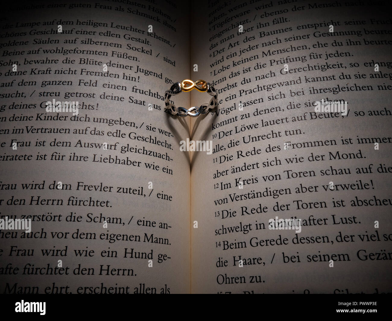 Einen goldenen Ring auf ein Buch, das einen Schatten in der Form eines ...