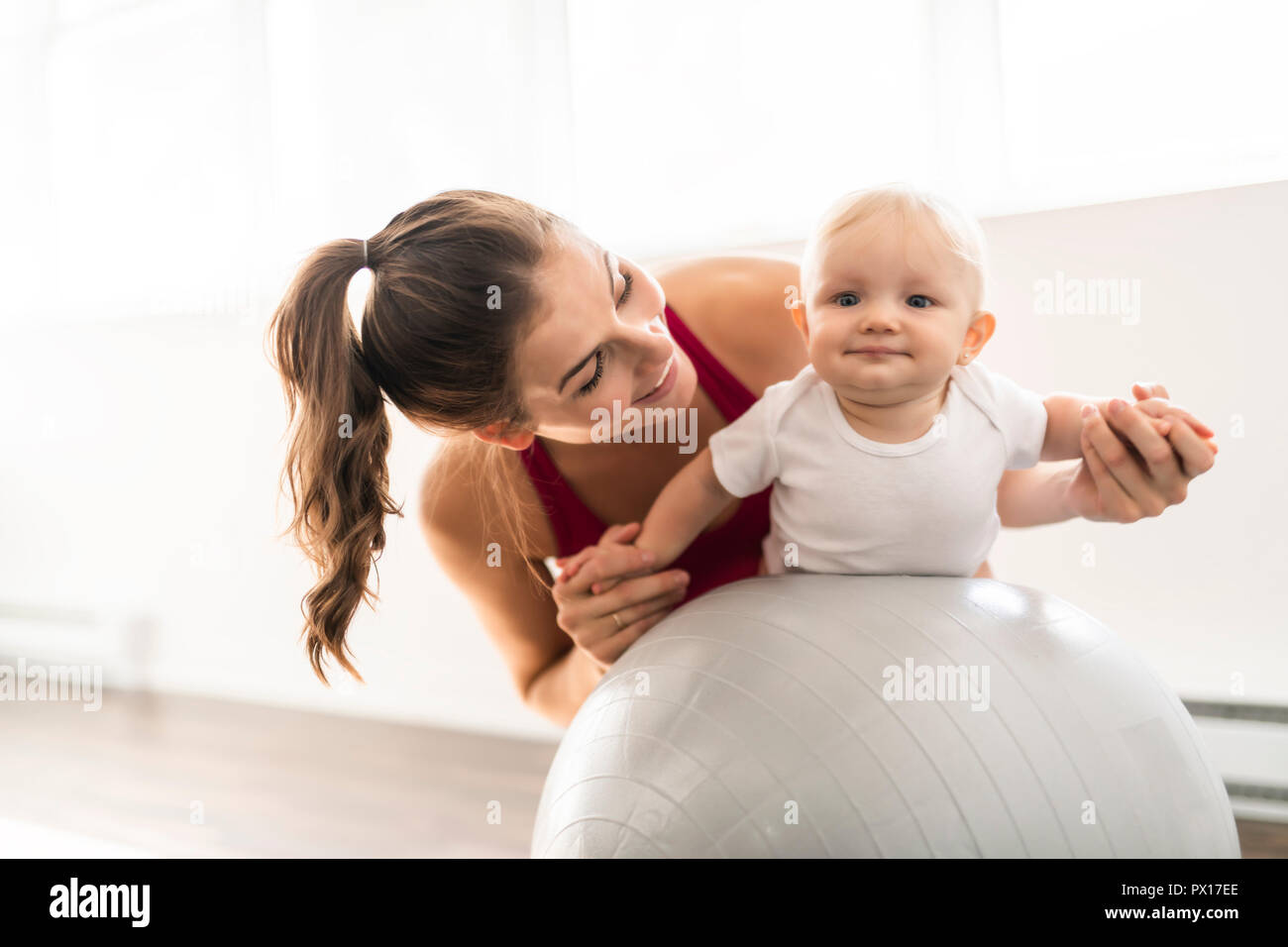 Ein Porträt der schöne junge Mutter in Sportbekleidung mit ihren ... Ein Porträt der schöne junge Mutter in Sportbekleidung mit ihren ...