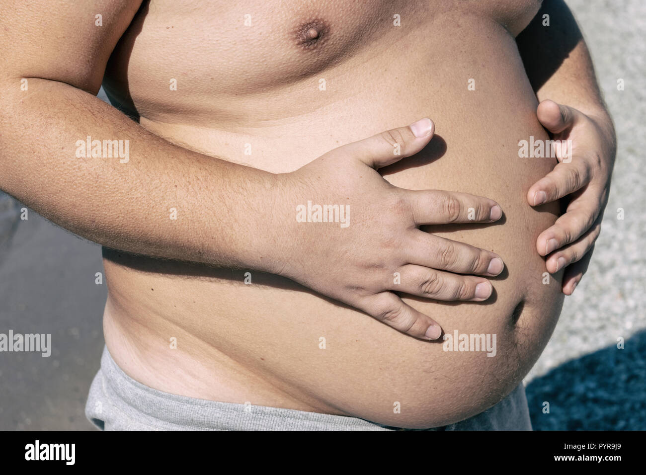 Fetter Mann mit großen Bauch stehend auf dem Ozean Stockfotografie - Alamy