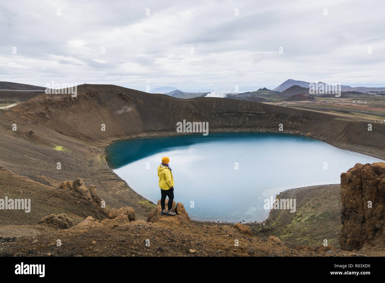Frau im gelben Regenmantel in die mit Wasser gefüllten Krater der ...