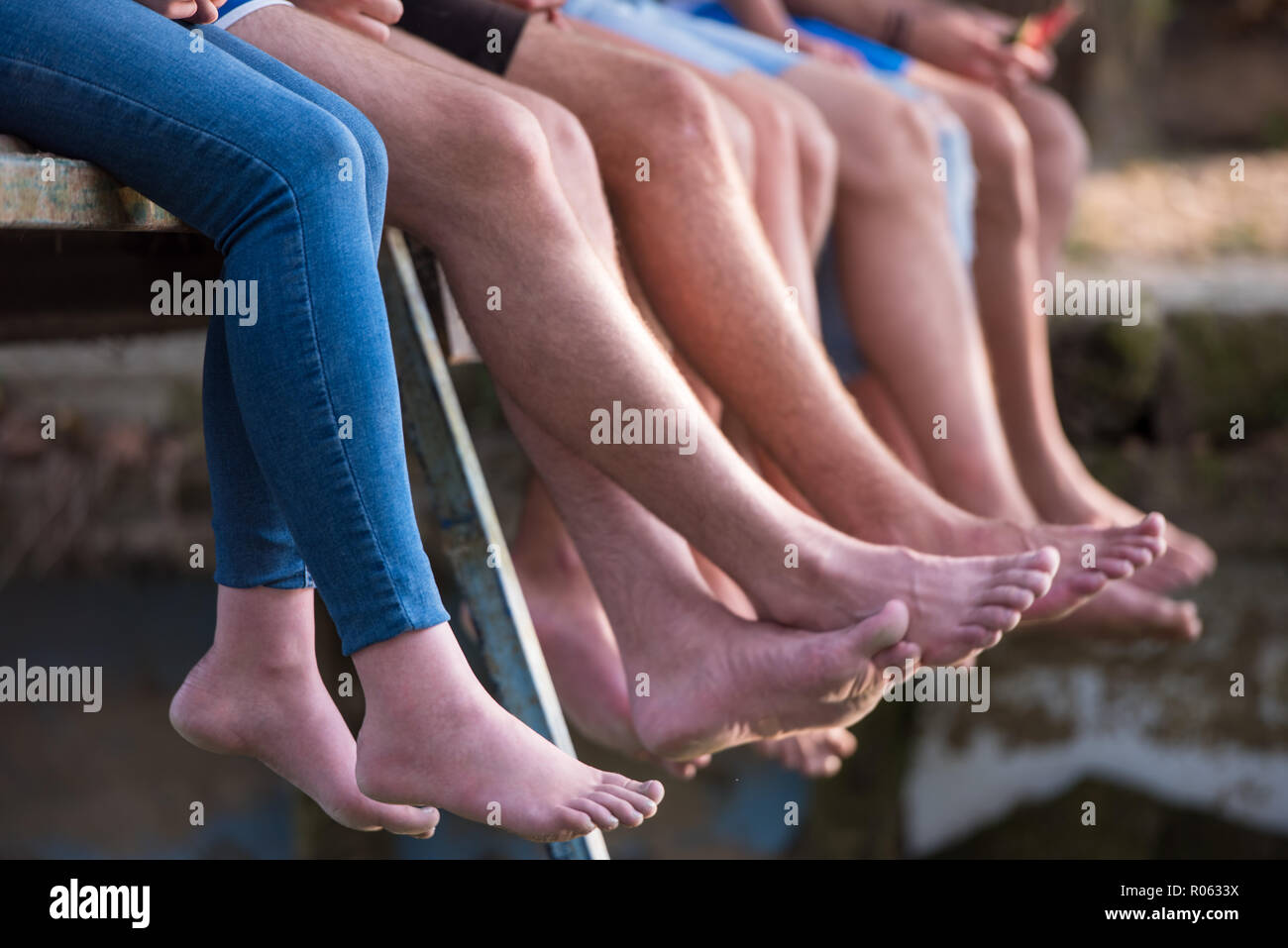 Gruppe von Menschen an der hölzernen Brücke über den Fluss sitzend mit ...