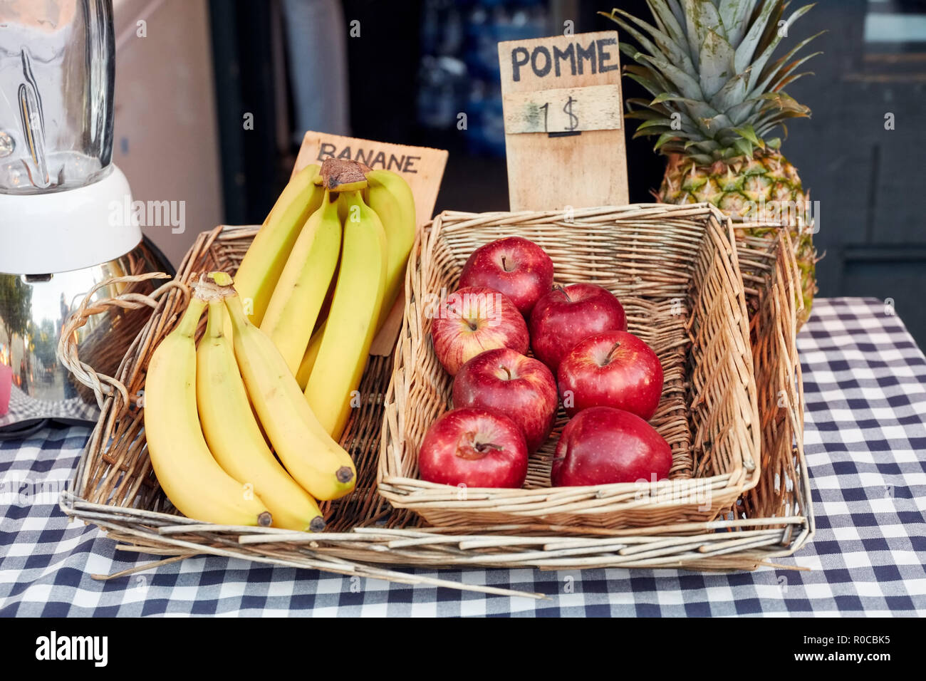Frische Apfel, Banane und Ananas in einem Korb und ein Mixer auf der ...