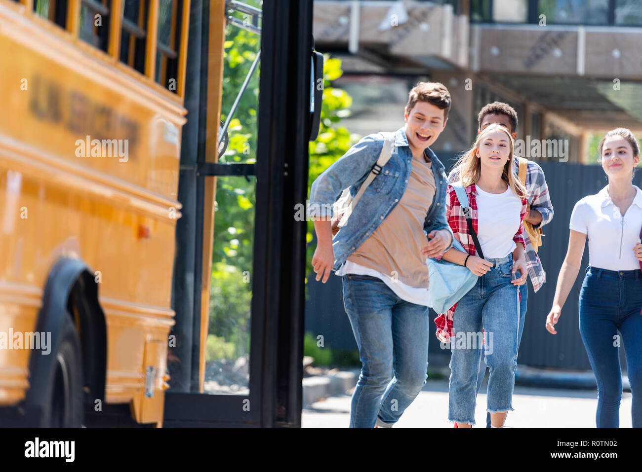 Gruppe von Happy Teen Gelehrten mit dem Bus zur Schule nach dem ...