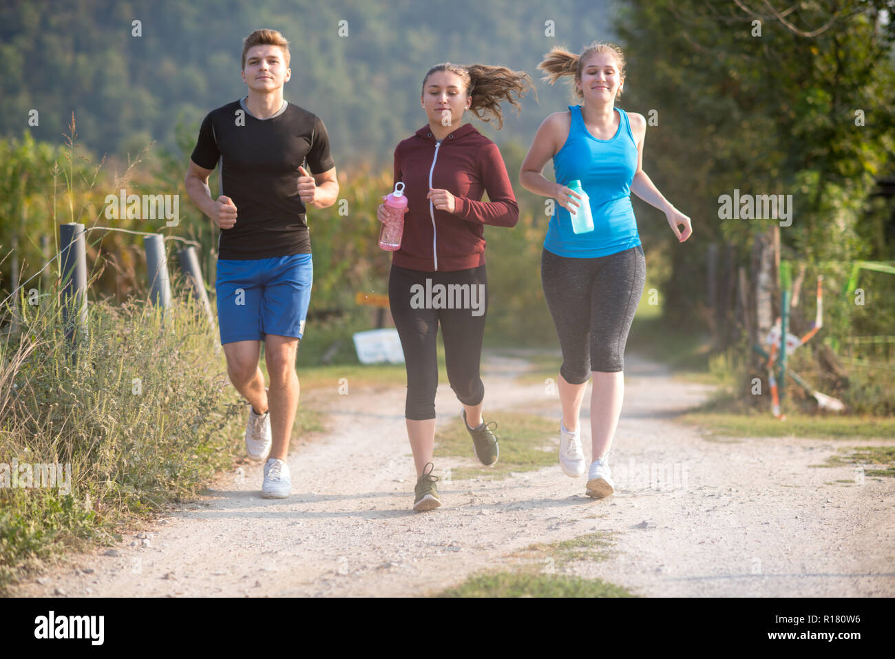 Eine Gruppe der Jungen Jogging auf Country Road Runners, die auf ...