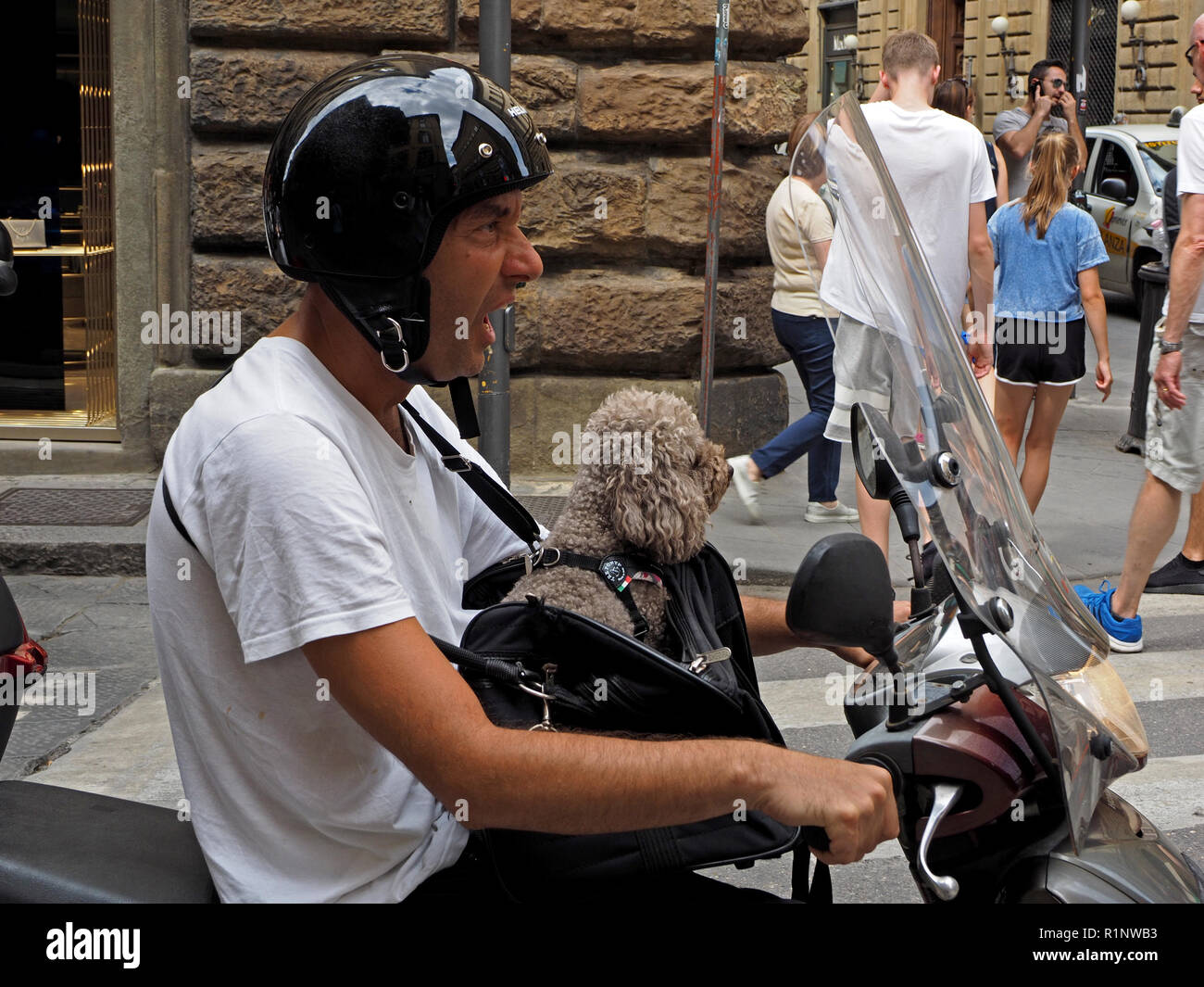 Gähnen Mann auf Scooter mit weißem T-Shirt und schwarzem Helm tragen ...
